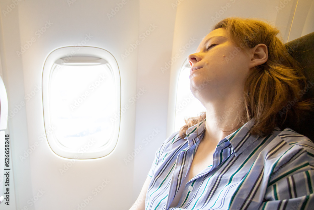 Tired Passenger Sleeping In The Plane Cabin During A Long Flight In The