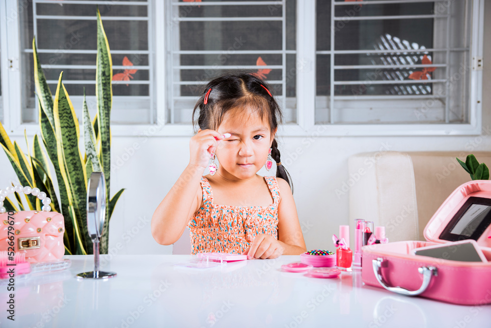 Asian adorable funny little girl making makeup her face she applying ...
