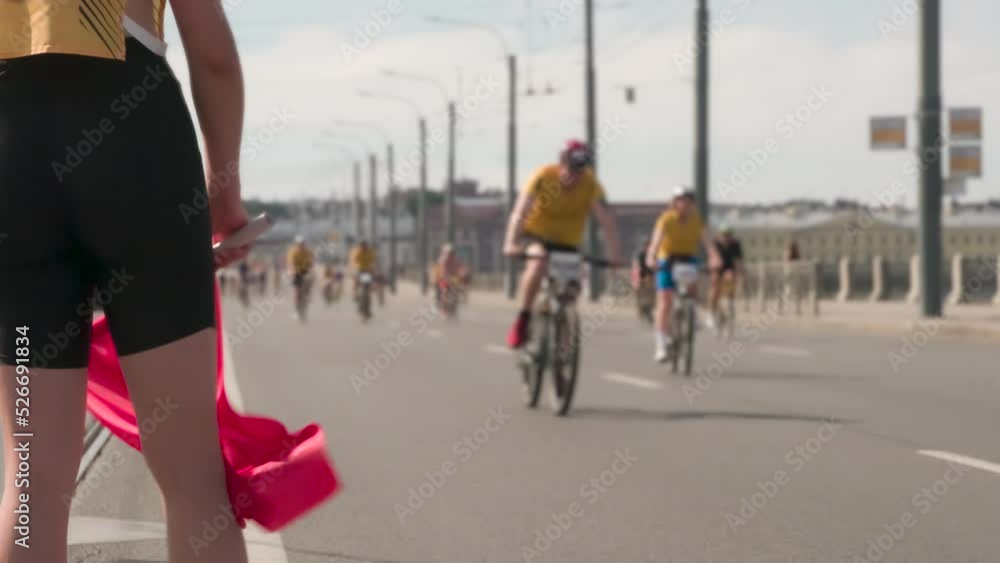 Volunteer Guides Cyclists. Volunteer waving a signal flag to help the ...