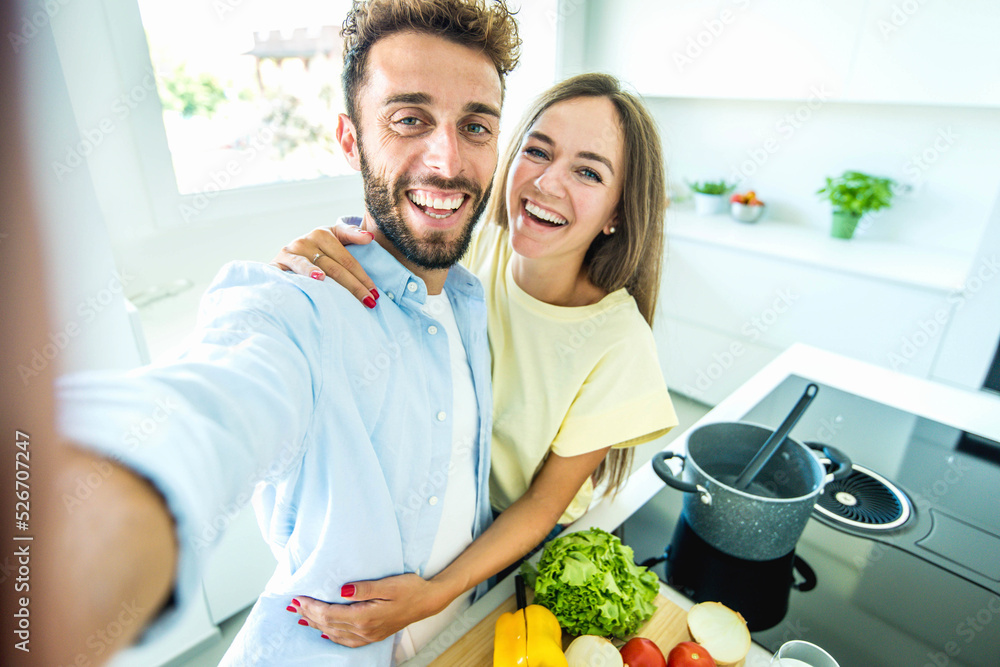 Young happy couple preparing healthy meal in kitchen at home - Husband ...