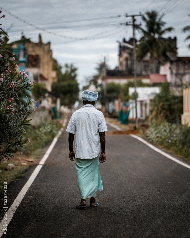 Vertical back view of an Indian male walking in the streets of ...