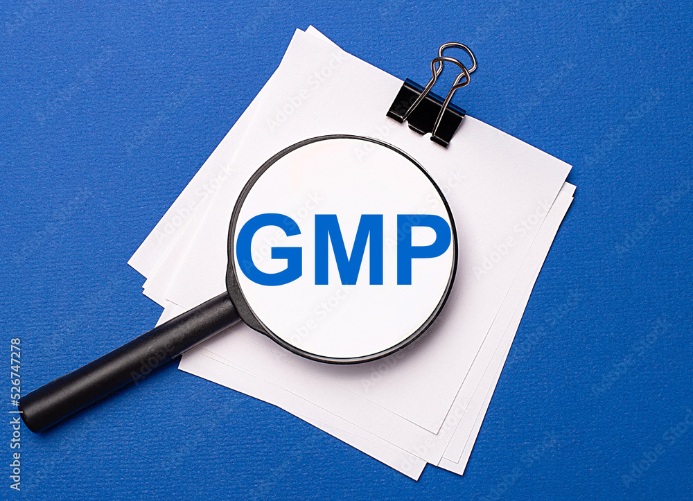 On a blue background, white sheets under a black paper clip and on them ...