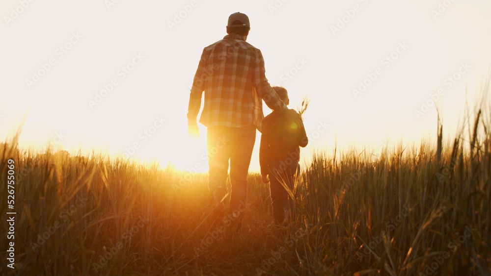 Farmer and his son in front of a sunset agricultural landscape. Man and ...