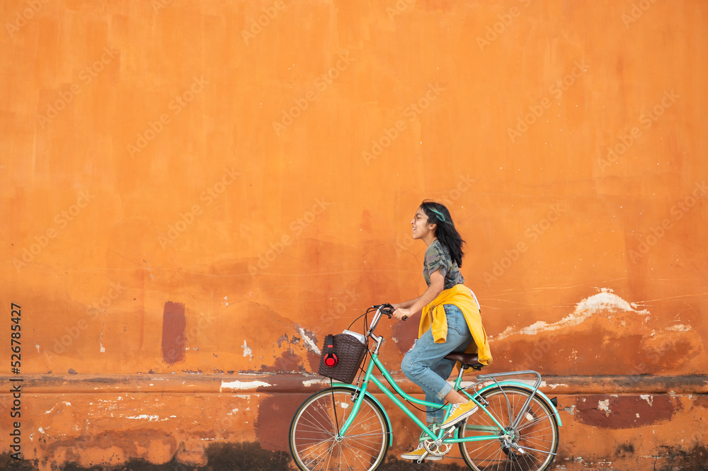 young woman on a bicycle. A beautiful Hispanic teenage girl riding a ...