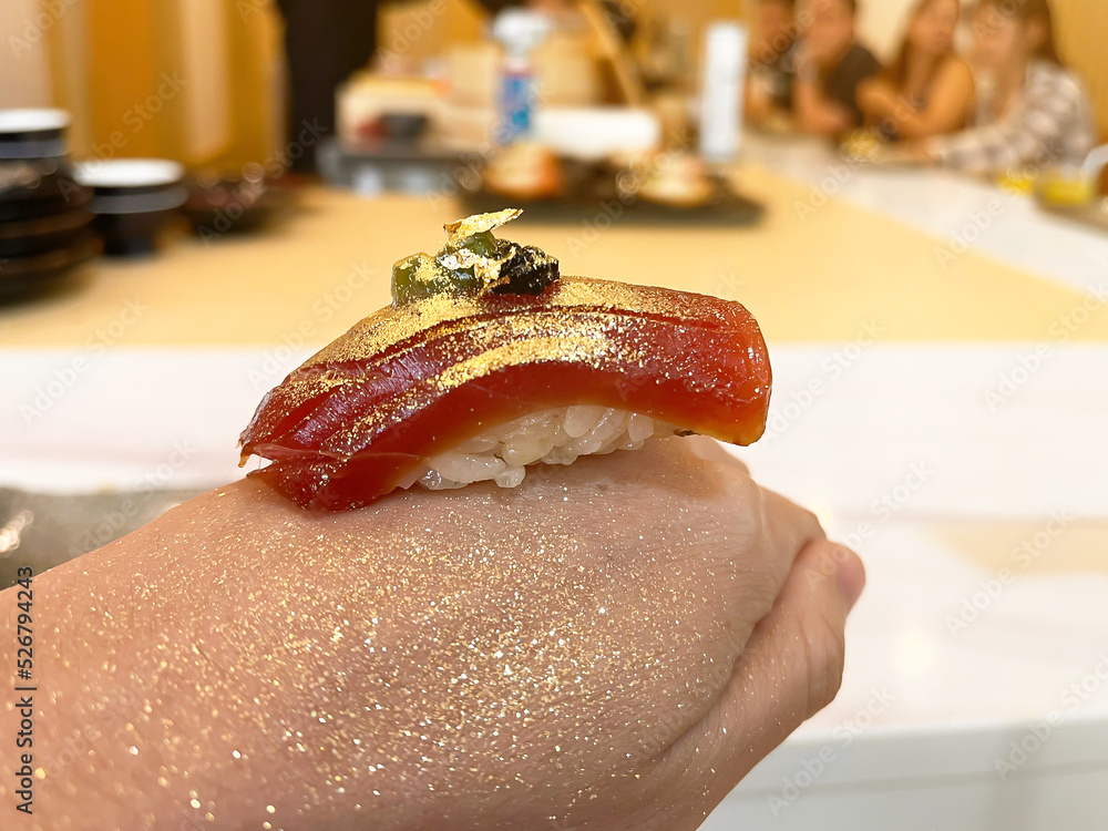 Japanese omakase meal; chef served Akami nigiri on back hand (is a ...