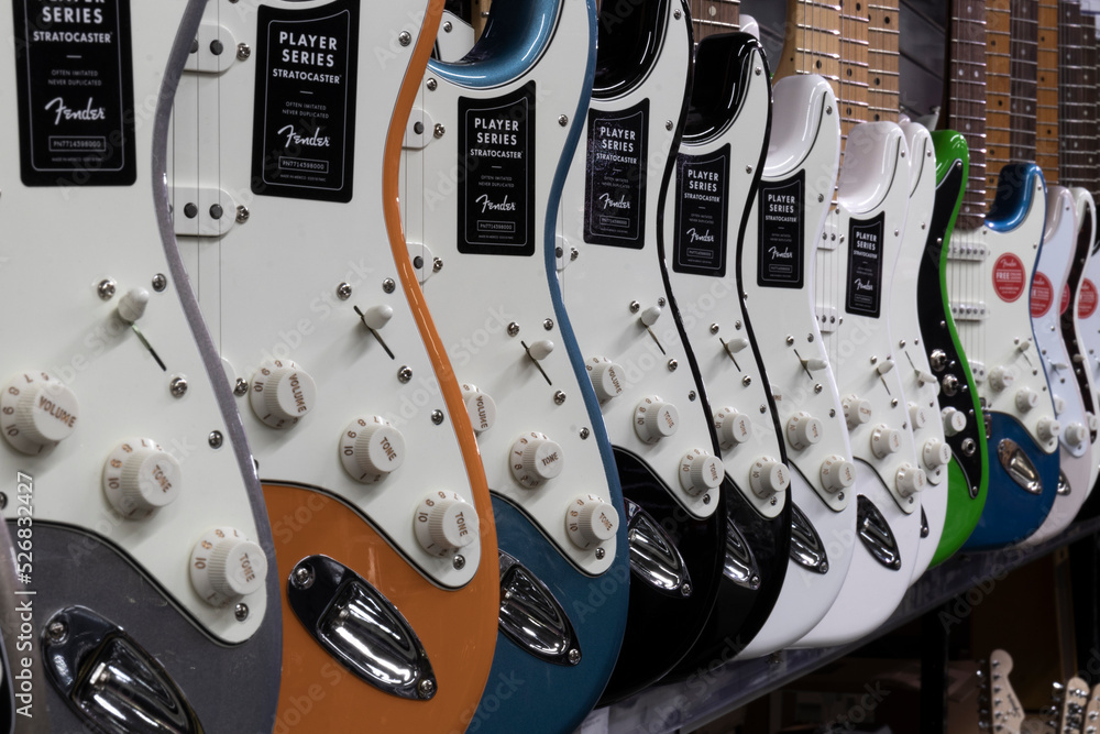Fender Stratocaster guitar display at a music store. Strats are world ...