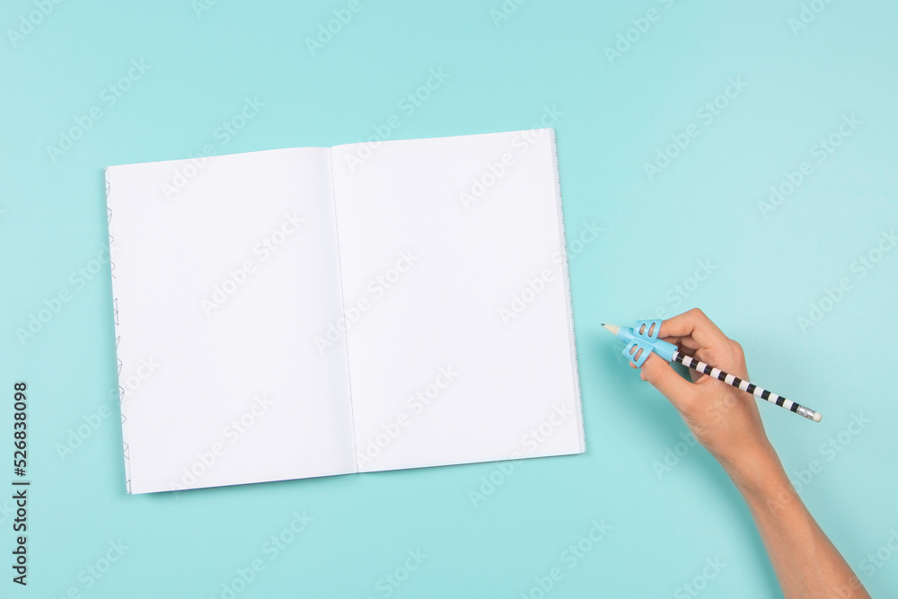 Kid hand using pencil with silicone three finger pen. Top view to hand ...