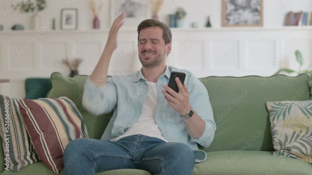 Young Man having Loss on Smartphone at Home Stock Video | Adobe Stock
