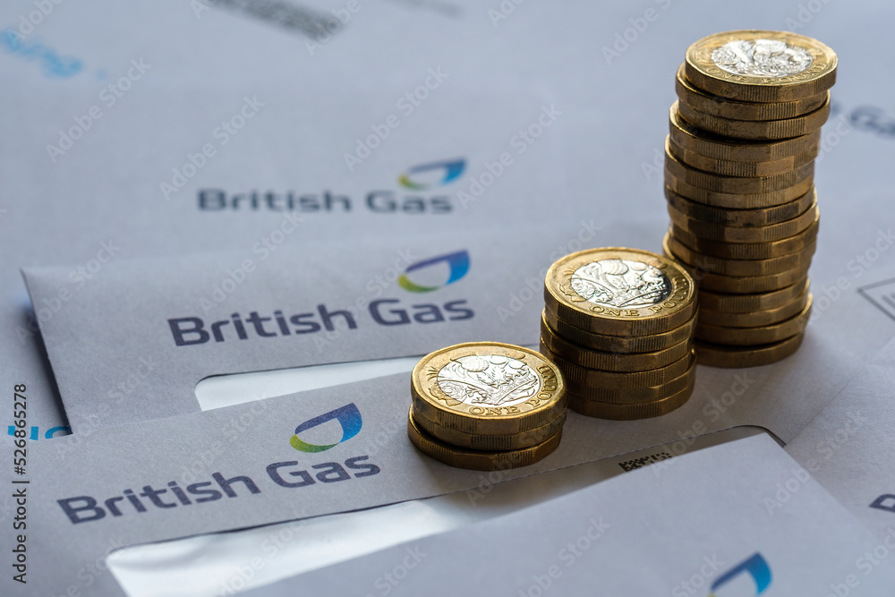 Stacks of One Pound coins on top of British Gas bills in the envelopes ...