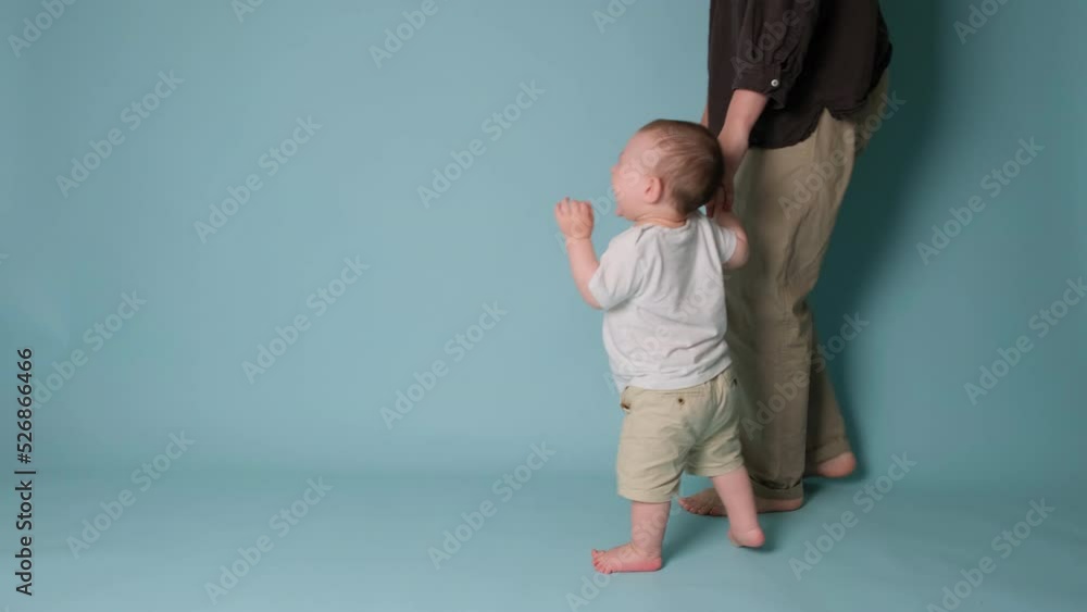 Happy toddler baby learns to walk and takes his first steps with the ...