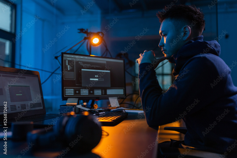 cybercrime, hacking and technology concept - male hacker in dark room ...