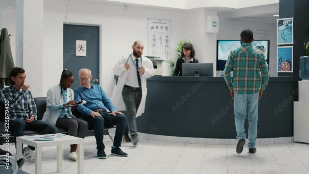 Diverse group of patients sitting in waiting room at hospital ...
