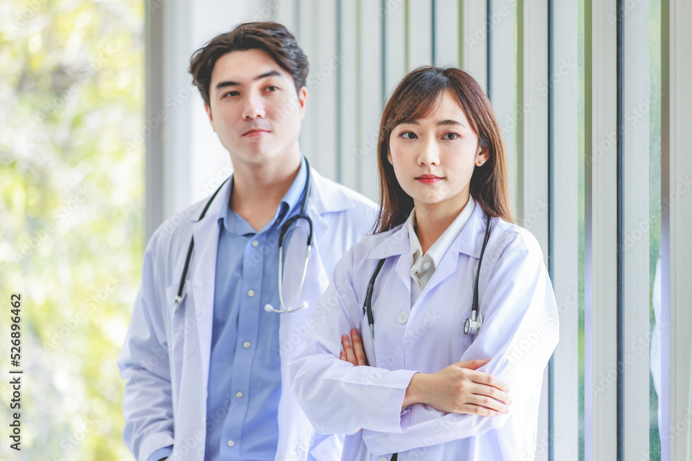 Asian young cheerful professional male and female intern practitioner ...