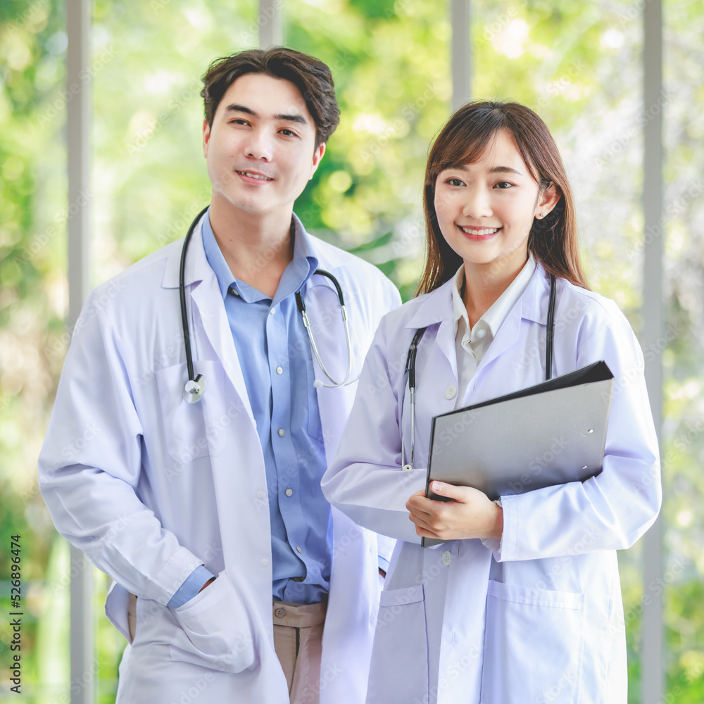 Asian young cheerful professional male and female intern practitioner ...