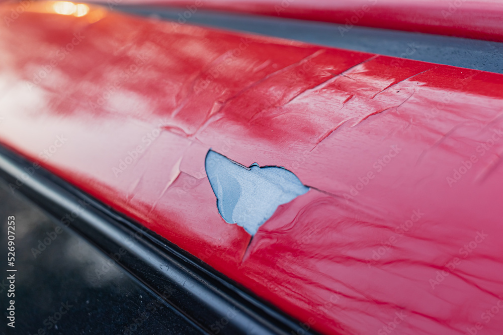 The red car paint peels off, the car paint cracks and falls off. Stock ...