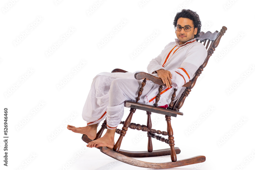 Portrait of Bengali man sitting on rocking chair against white ...