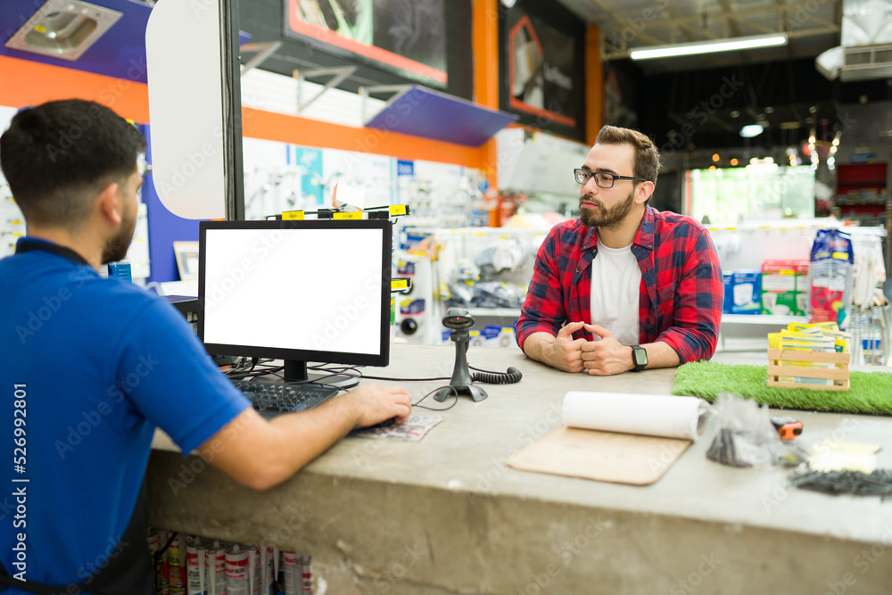 Rear view of a hardware store cashier with a male customer at checkout ...