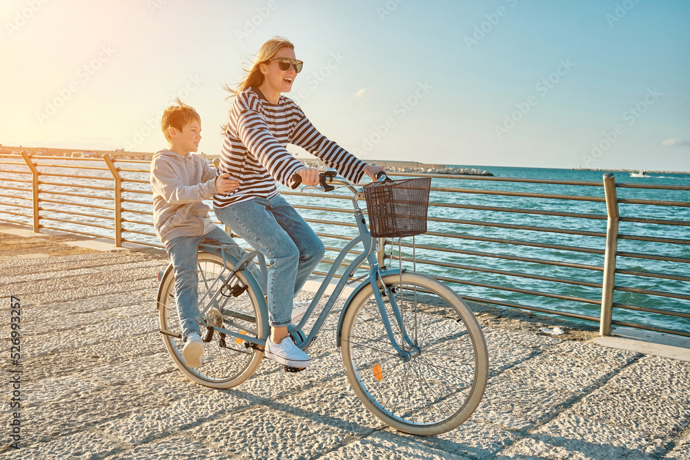 Happy family, Carefree mother and son with bike riding on beach having ...