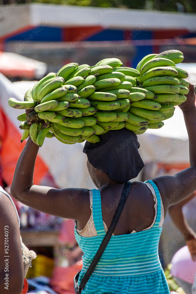 Haitian lady carrying a bunch of green plantains on her head in the ...