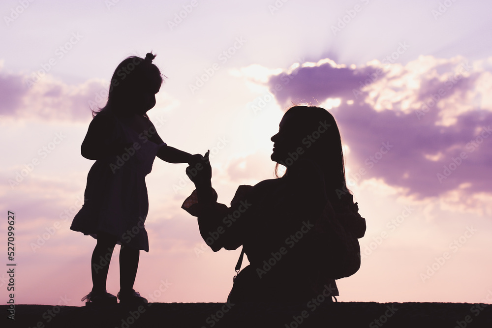Foto de A mom, mother holding by the hand a little daughter against a ...
