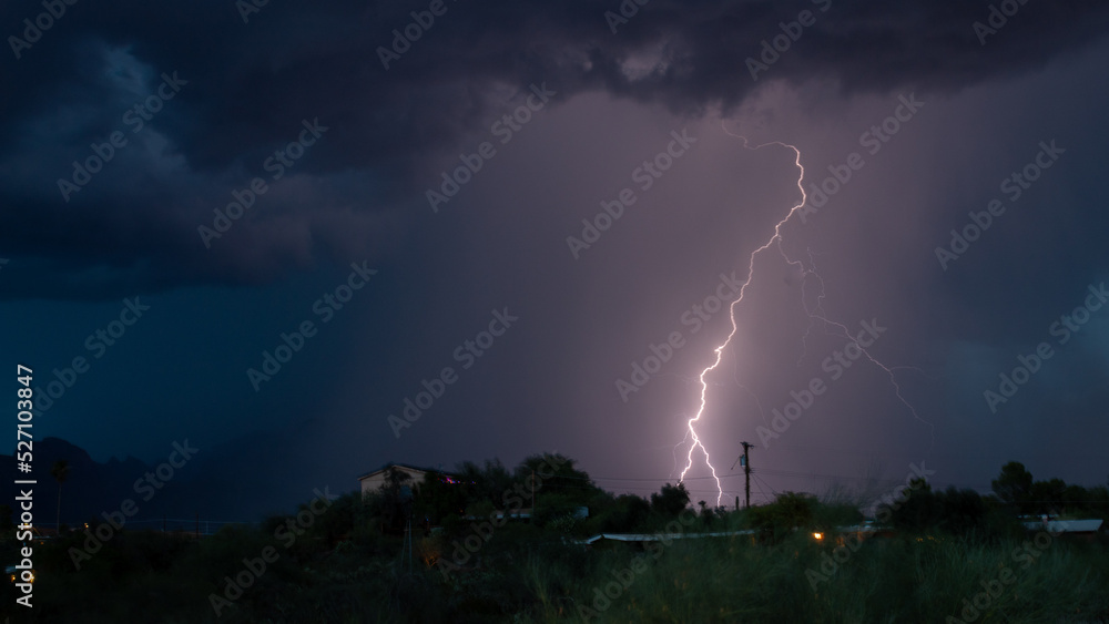 Lightning bolt and monsoon storm clouds over the Catalina Mountains in the Sonoran Desert north ...
