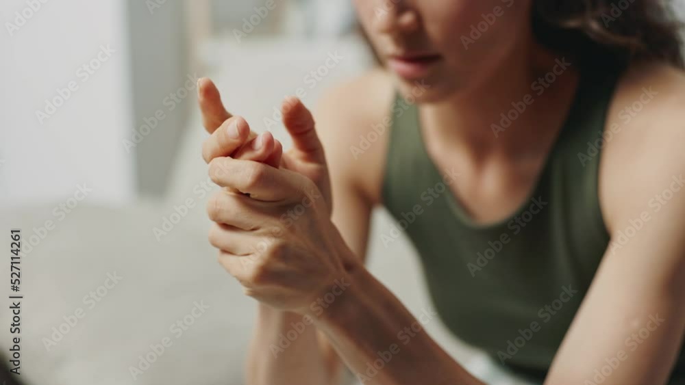 Woman in emotional distress rubbing her shaking hands sad and tired is ...