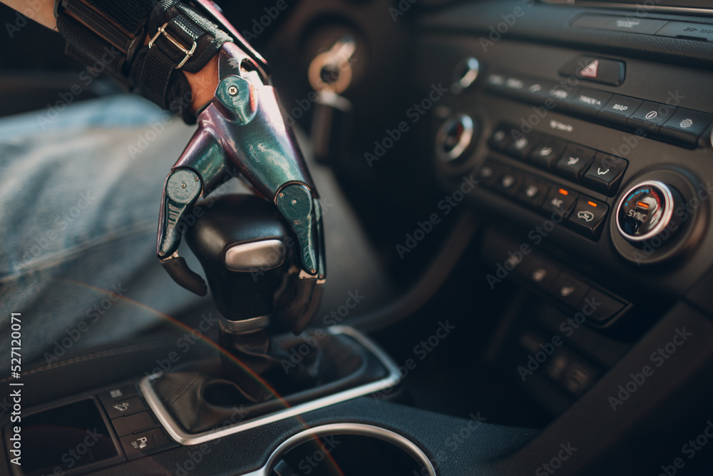 Young disabled man driver with artificial prosthetic hand driving ...