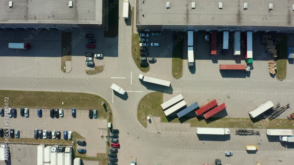 Top down view of a distribution warehouse. Semitrailers load cargo ...