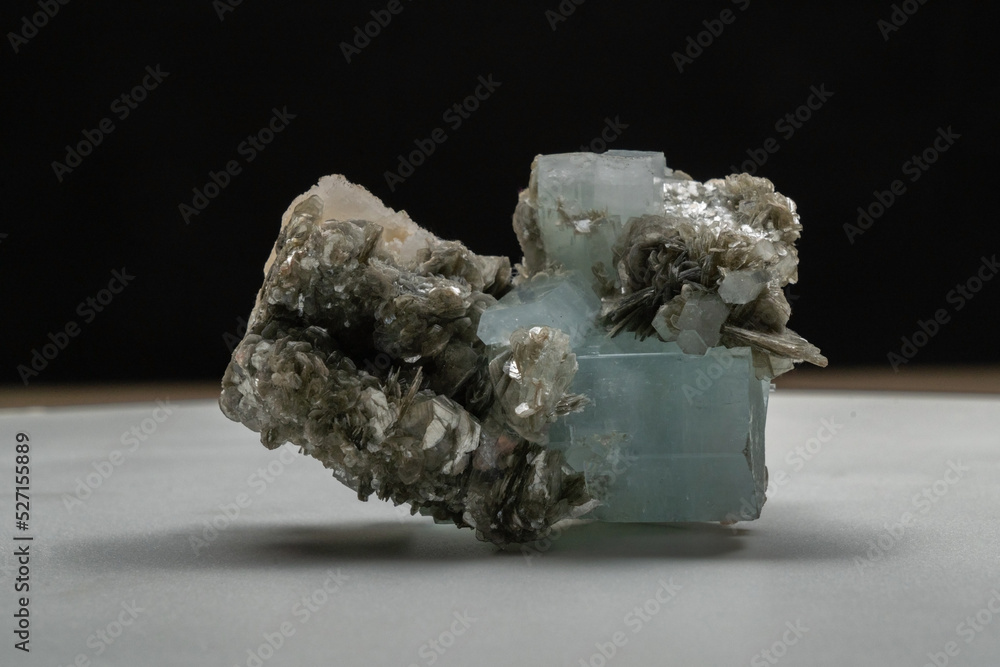 blue crystal with beautiful metallized crystals on a light plane black ...