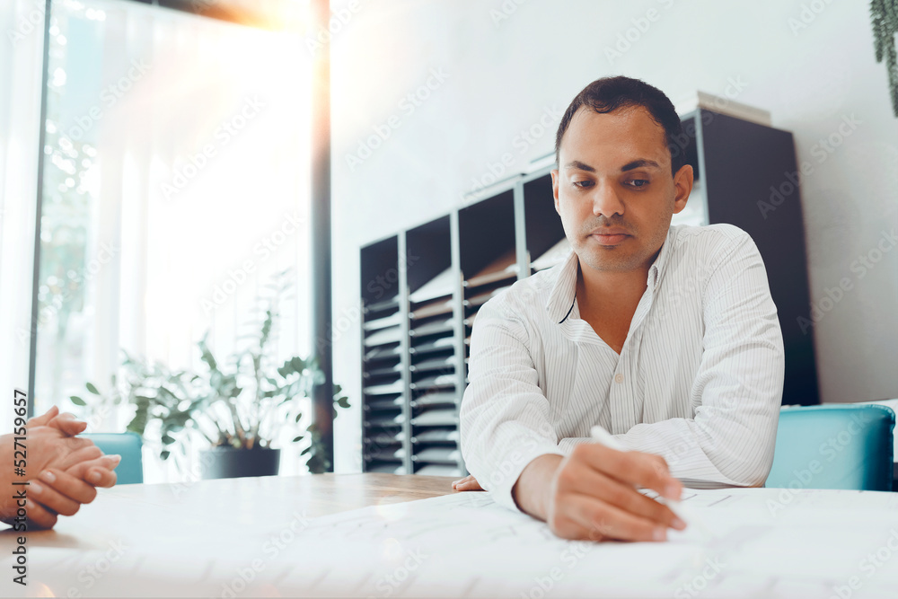 Engineer helping to design work on blueprints and collaborate on ...