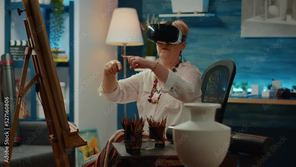Senior woman using vr glasses with augmented reality to create drawing ...