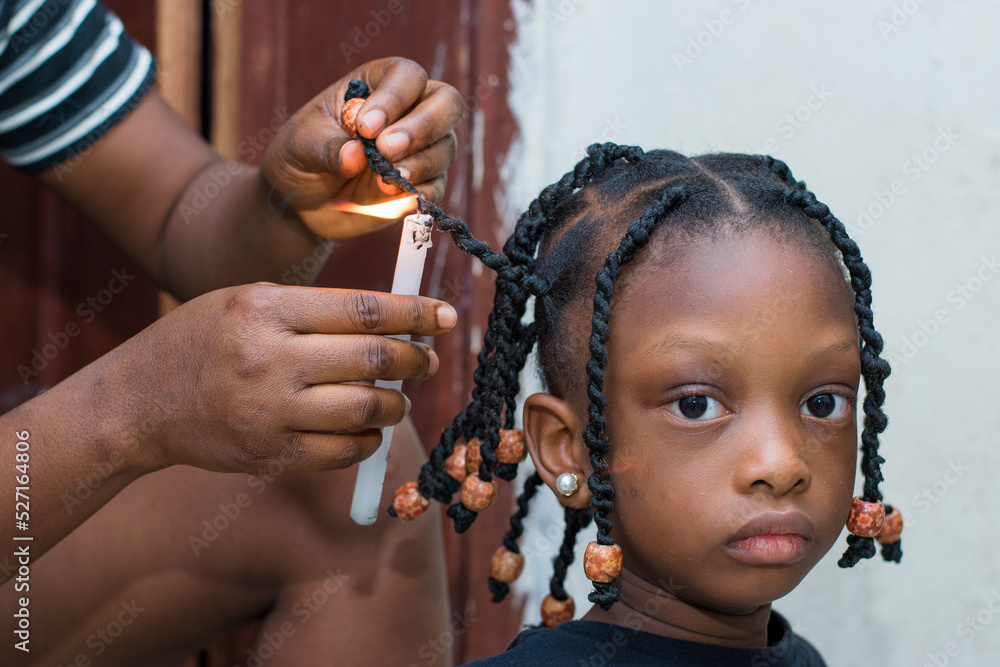 Hands of an african hair stylist or mother making braided hairstyle on ...