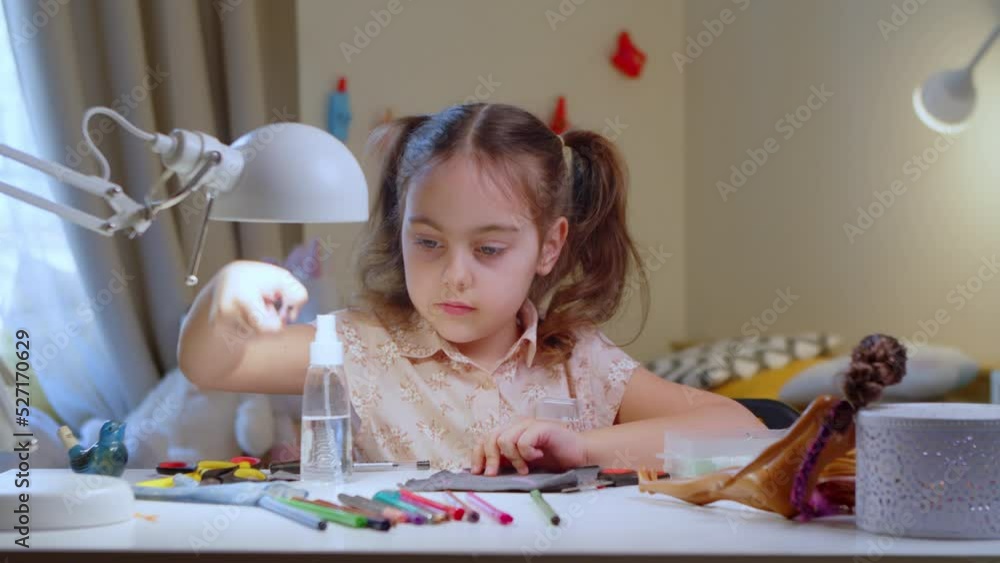 Focused cute preschooler girl doing crafts at home at the desk. little ...