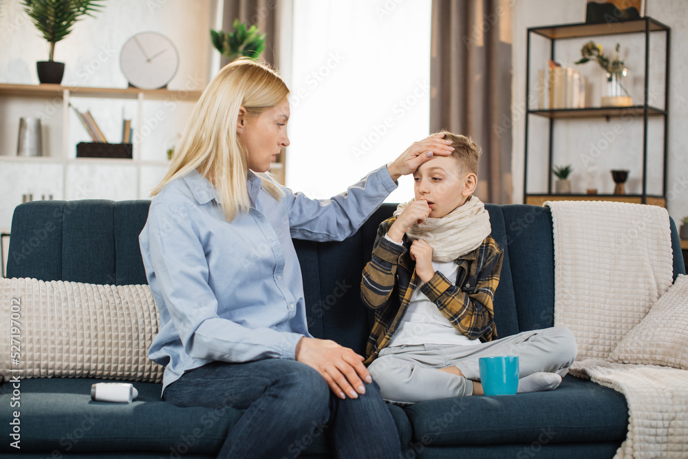 Stay at home. Mother taking care of her cute sick teen boy suffering ...