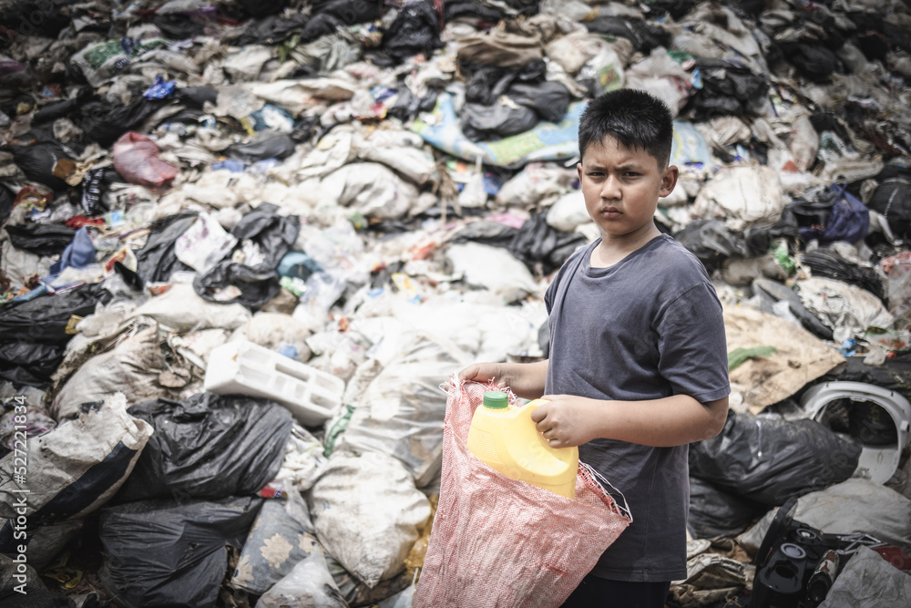 A young poor Indian boy collection waste plastic bottles in his sack to ...