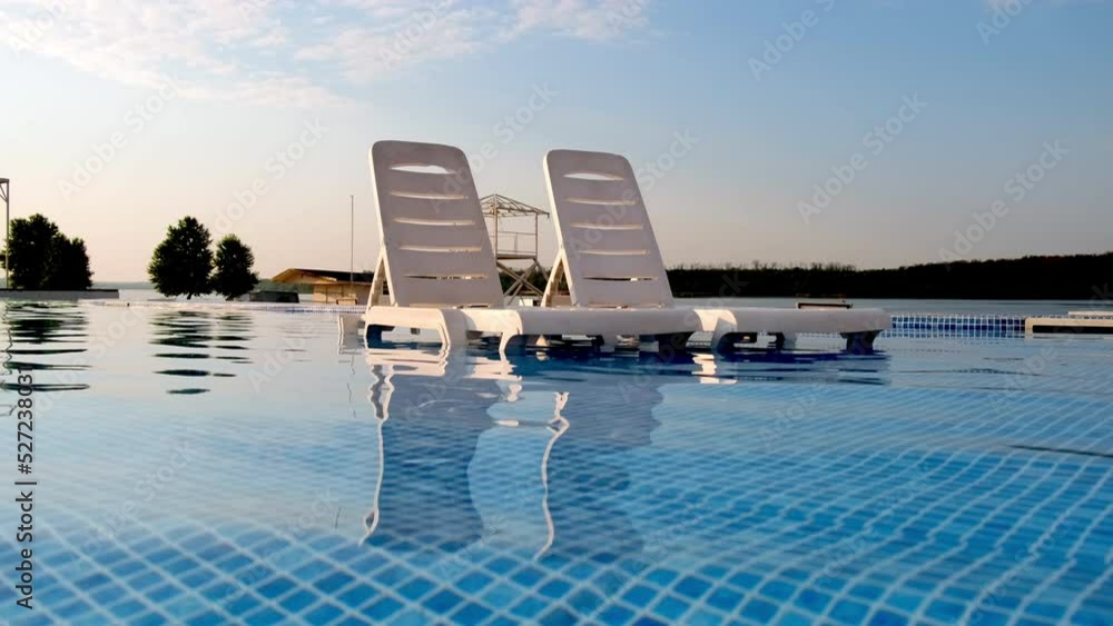 Swimming pool and white bed with water ripples. Luxurious resort pool ...
