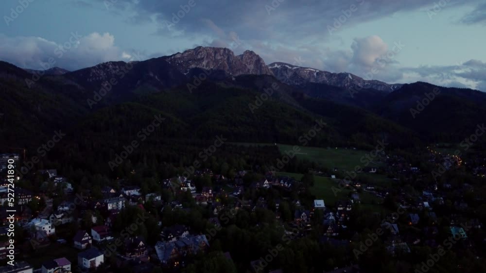 Night time flyover of Zakopane, Poland, a resort town against the Tatra ...