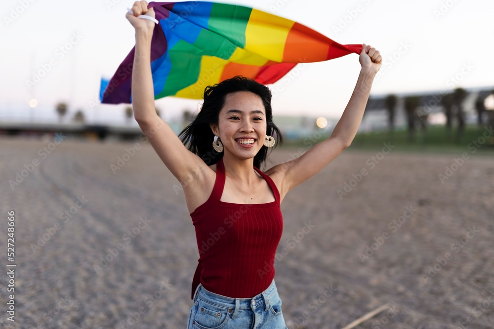 Young girl with a pride flag at the beach. LGBT community. Stock Photo ...