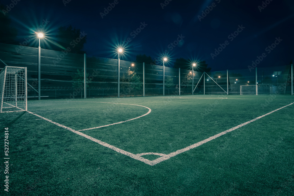 Foto de An amateur soccer field illuminated at night. A small football ...