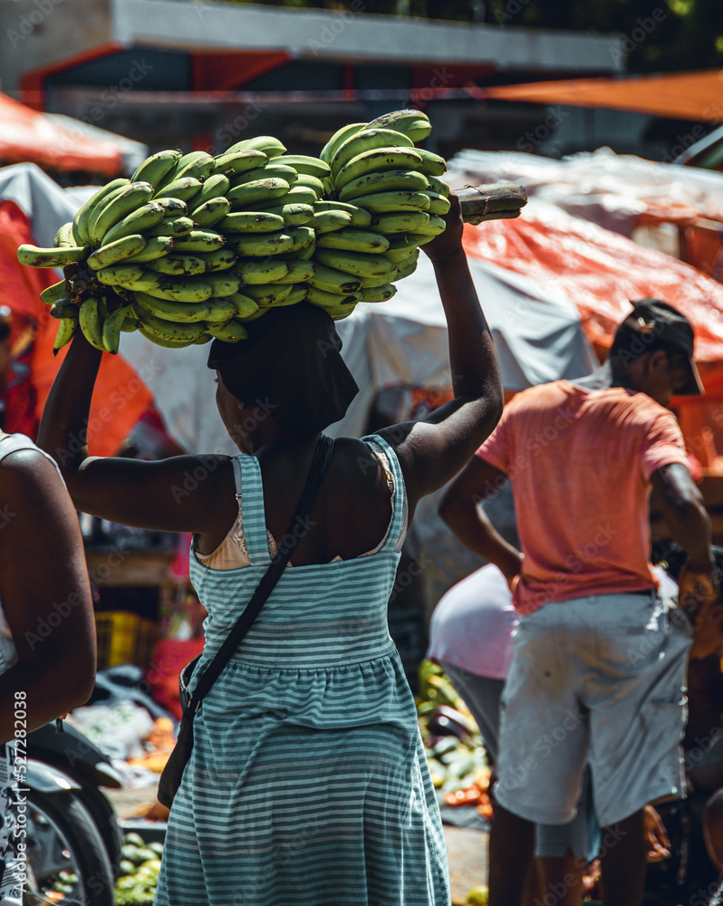 Foto de Haitian lady carrying a bunch of green plantains on her head in ...