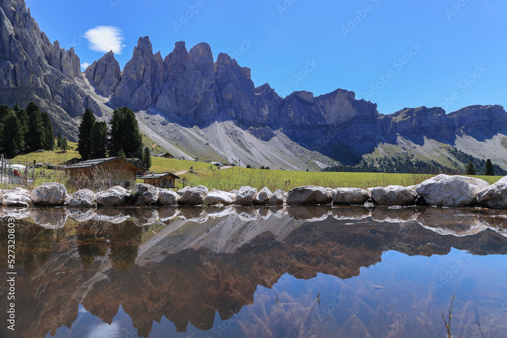 Reflection of Alpine peaks of Odle Group at Geisler Alm, Dolomites ...