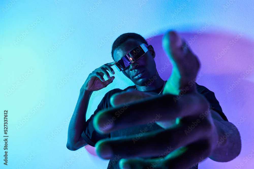 Confident black man in futuristic headset reaching out hand to camera ...