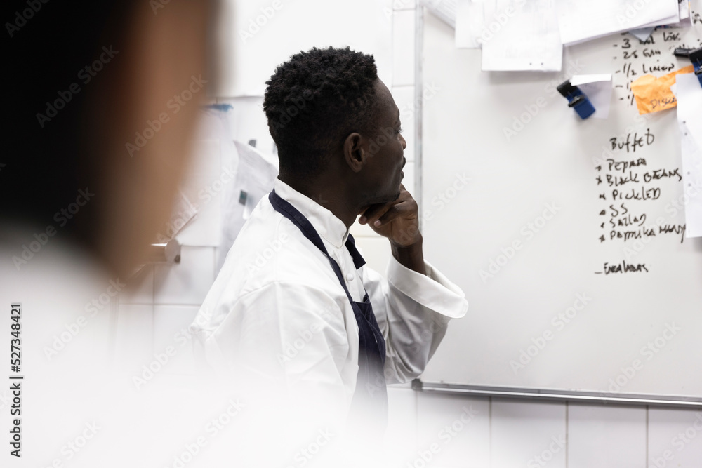 Chef reading menu on whiteboard in restaurant kitchen Stock Photo ...
