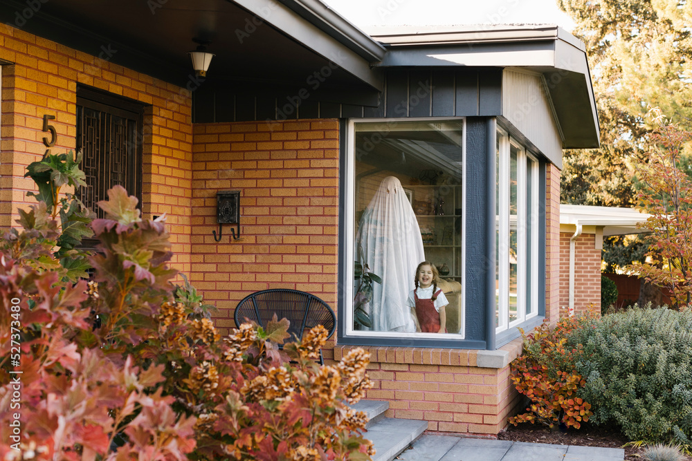 Little girl (2-3) and father dressed as Halloween ghost standing in ...