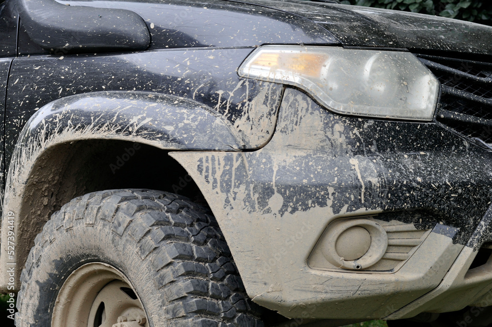 SUV covered in mud. The wheels and body of the car are splattered with ...