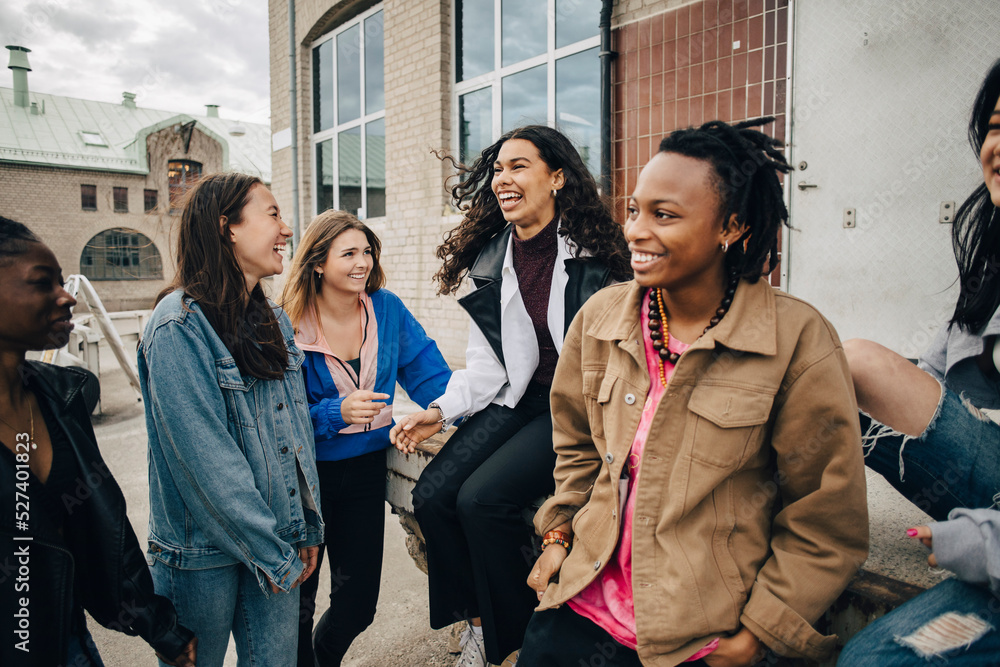 Happy multiracial young friends talking outside building Stock Photo ...