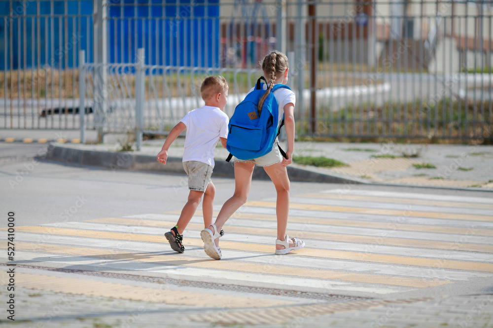 Brother and sister run across a pedestrian crossing. Children Run along ...