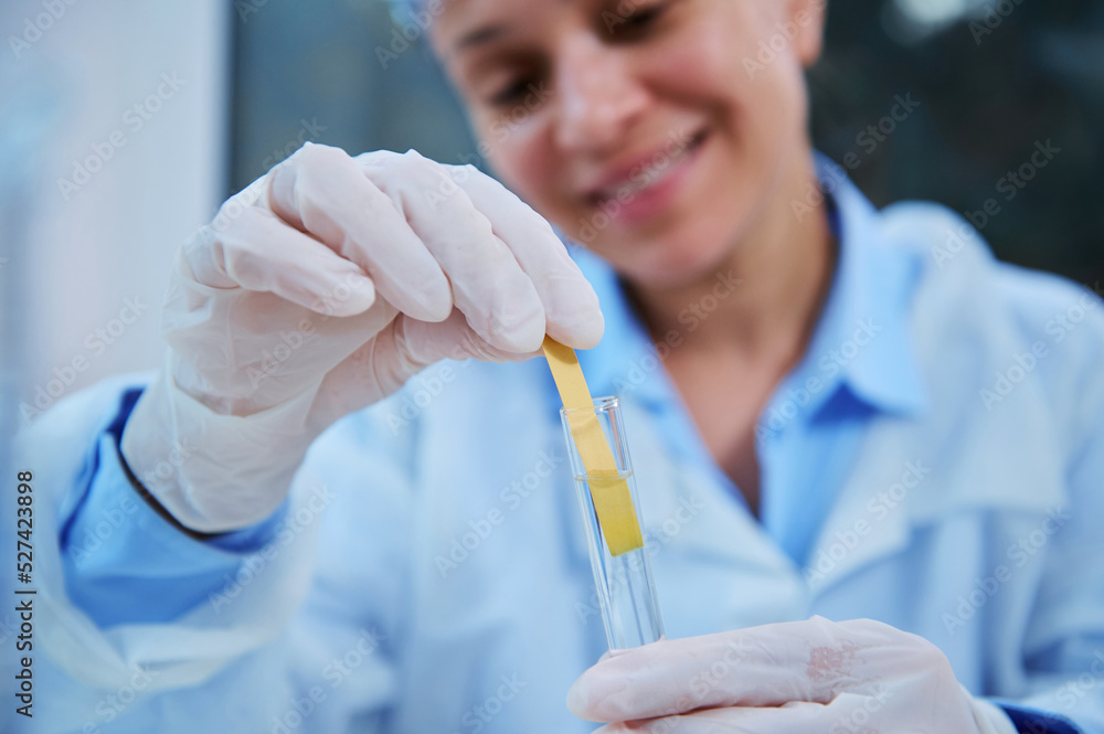 Selective focus on the hans of a blurred woman chemist scientist using ...