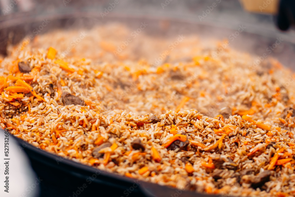 Background Yellow pilaf in cauldron with beef from street food market ...