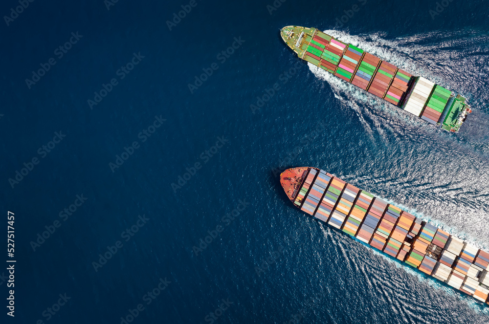 High aerial top down view of two container cargo ships traveling over ...